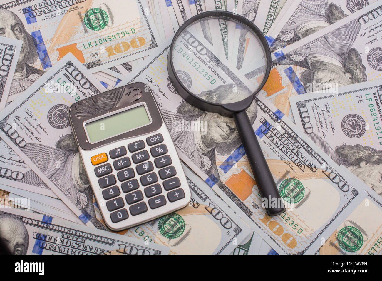 Magnifying glass is held over the banknote bundle of US dollar Stock ...