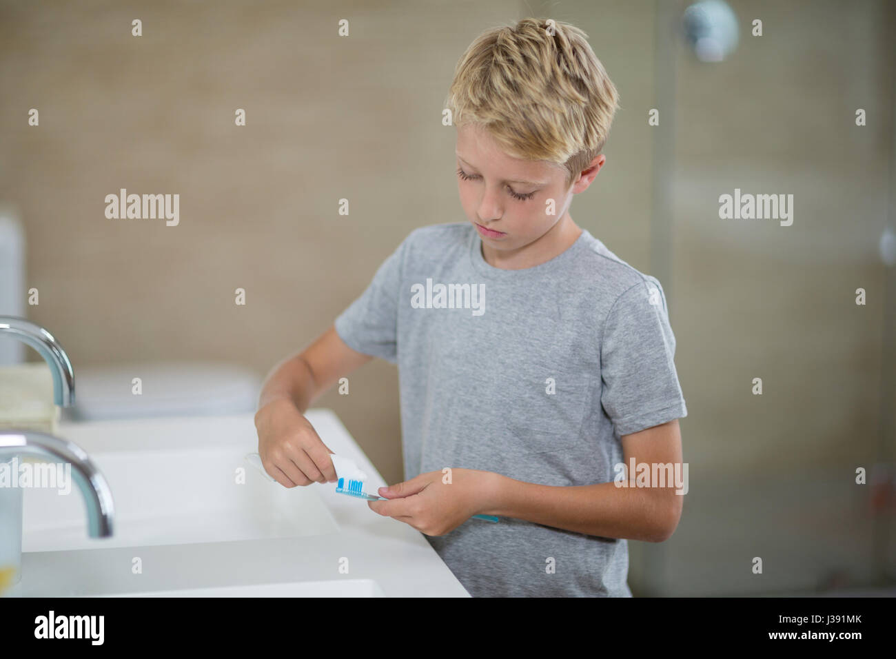 Boy putting toothpaste on brush in bathroom at home Stock Photo - Alamy