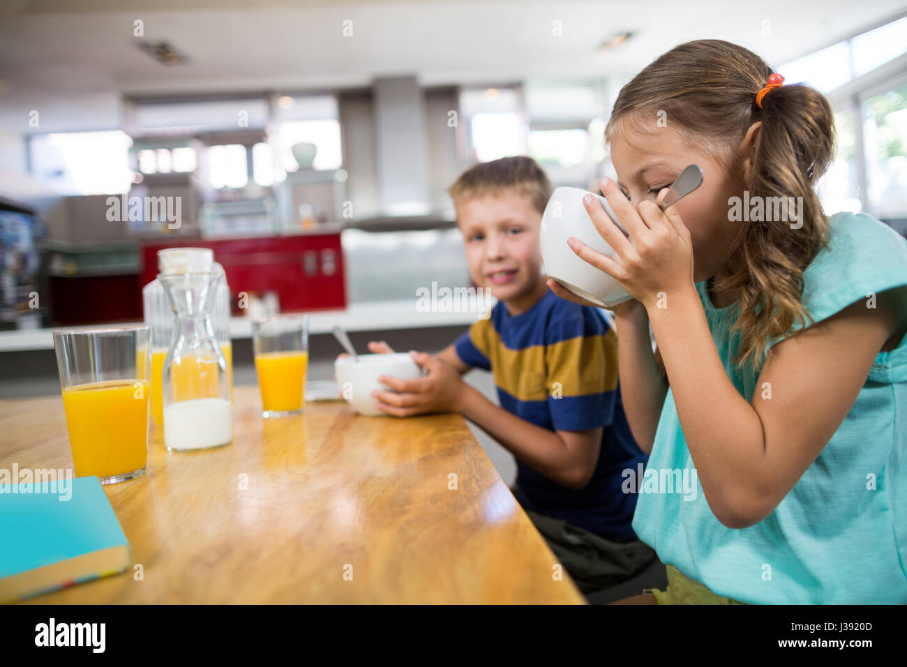 Sibling having breakfast cereal in kitchen at home Stock Photo - Alamy