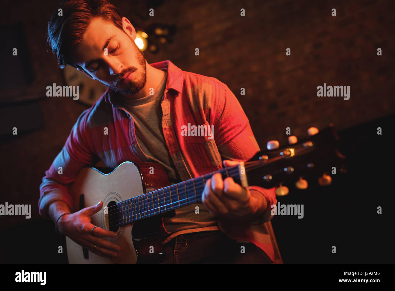 Young man playing guitar in pub Stock Photo - Alamy