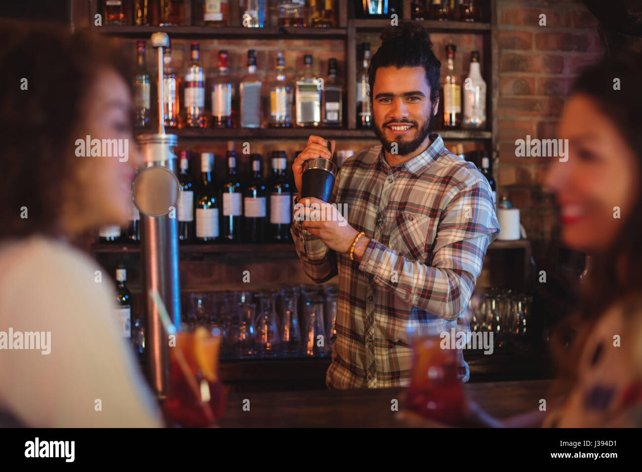 Bartender mixing a cocktail drink in cocktail shaker at pub Stock Photo ...