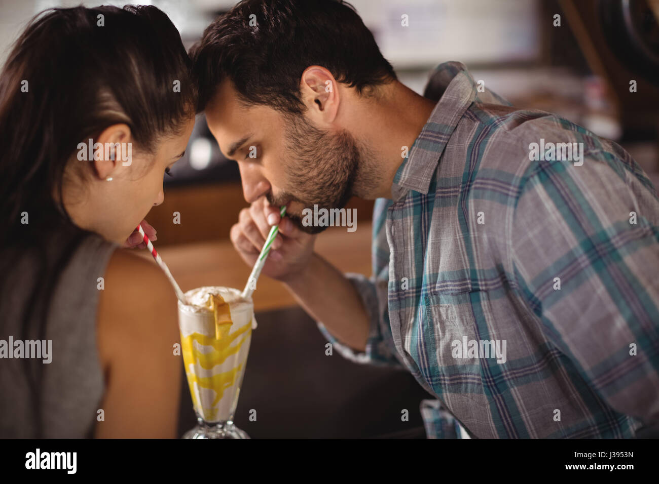 Close-up of couple having milkshake in restaurant Stock Photo - Alamy