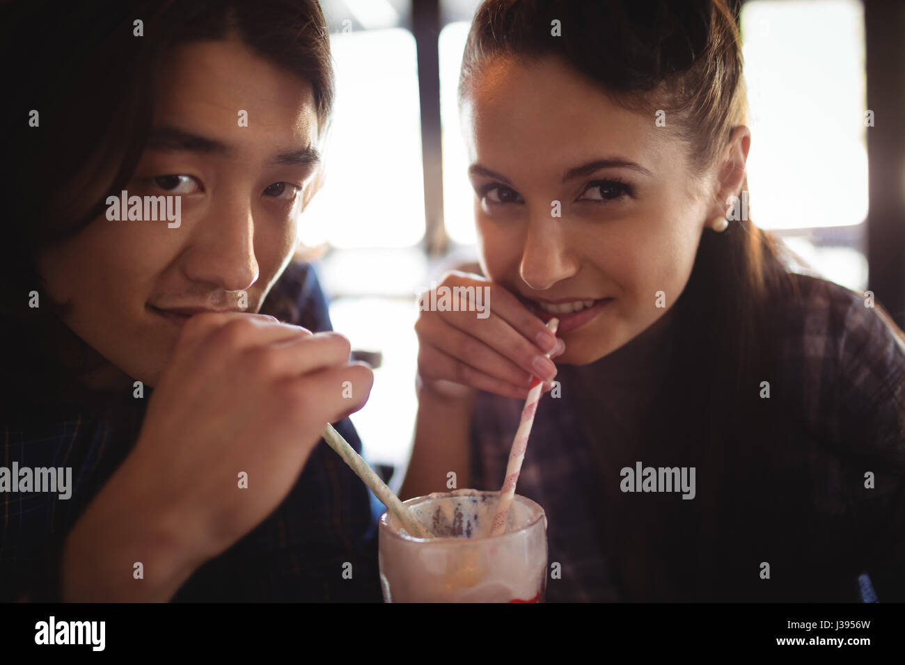 Portrait of couple having milkshake in restaurant Stock Photo - Alamy