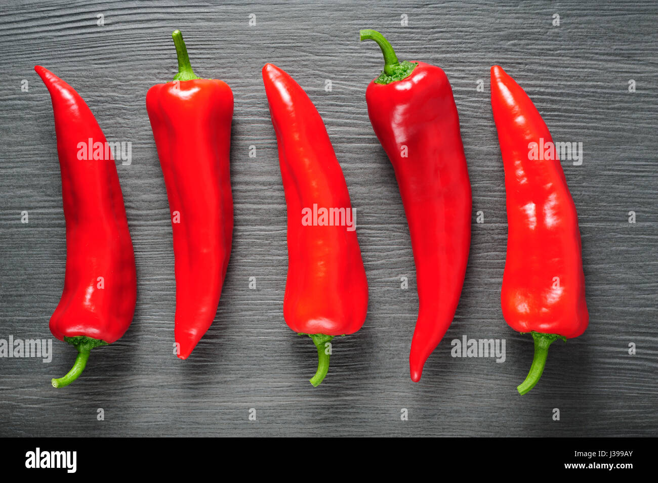 Five ripe sweet red Kapia peppers on dark shale stone background Stock ...