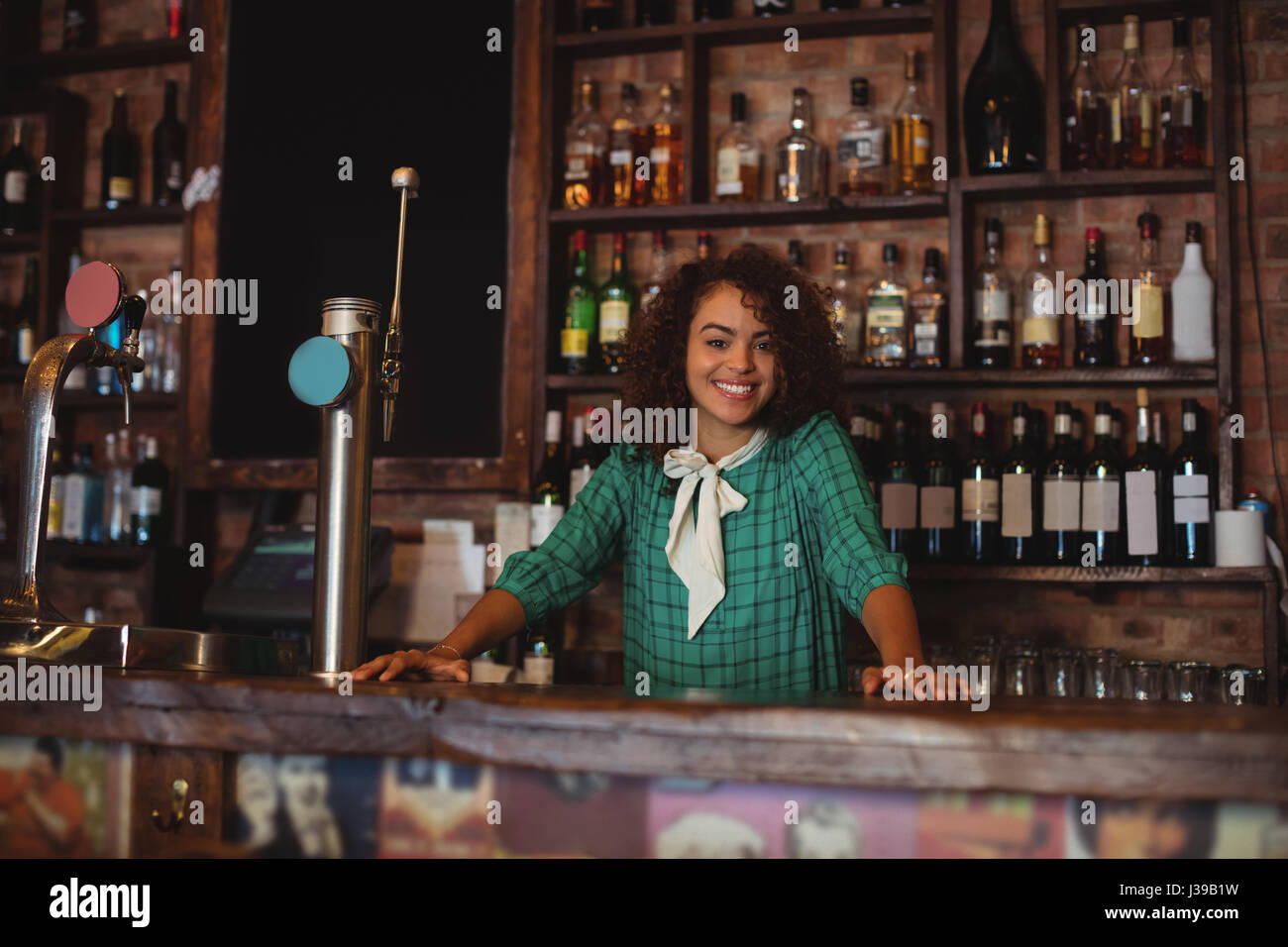 Portrait of beautiful female bar tender standing at bar counter Stock ...