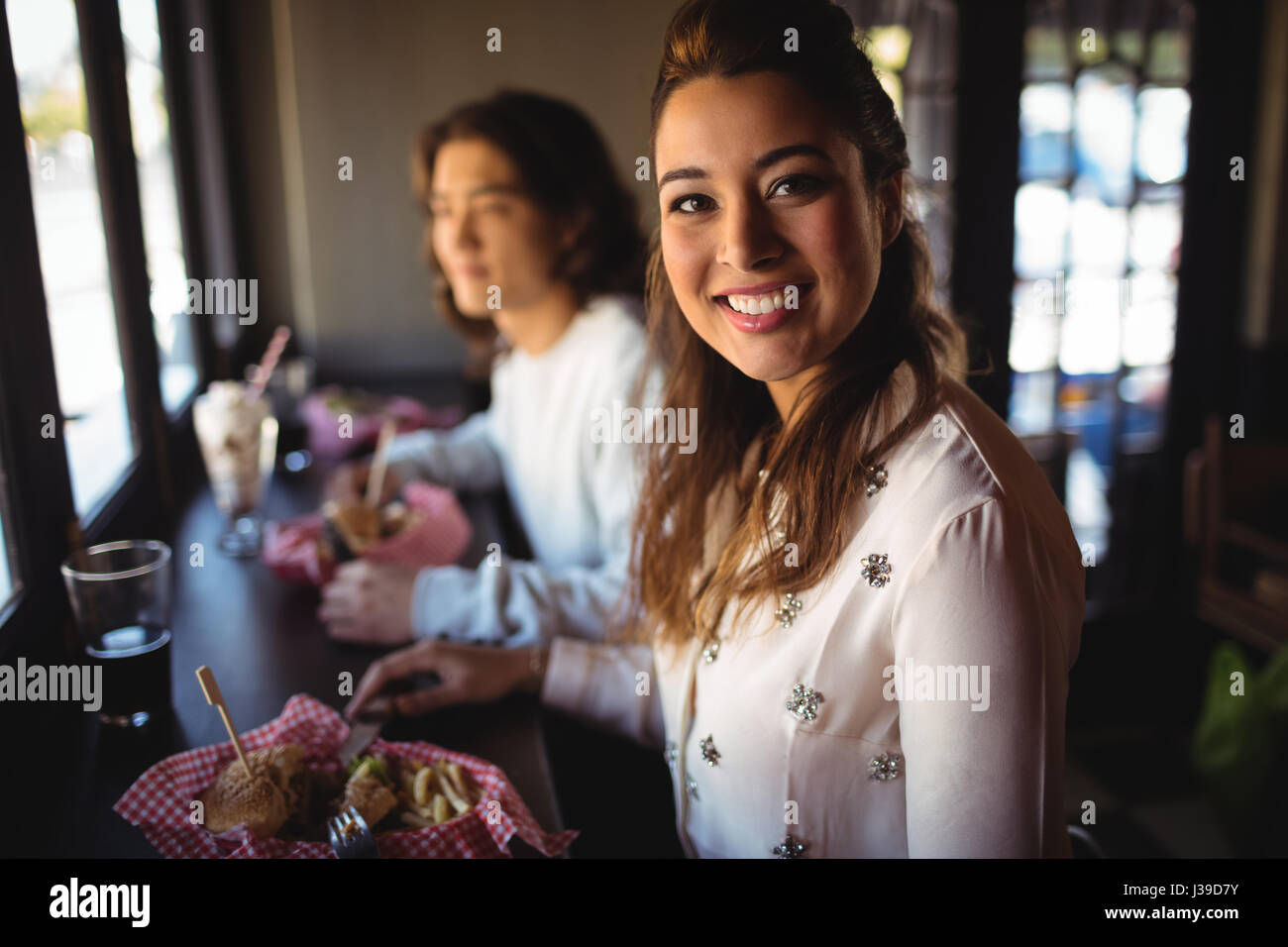 Friends having burger together at restaurant Stock Photo - Alamy