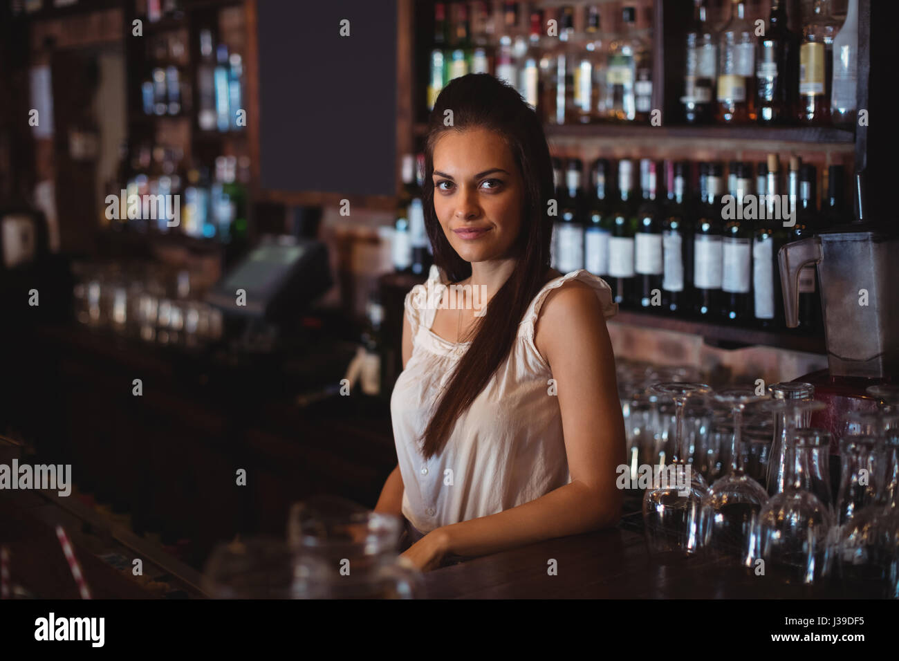 Portrait of beautiful female bar tender standing at bar counter Stock ...
