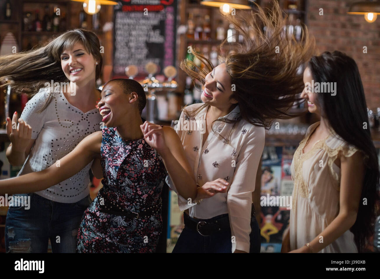 Carefree female friends dancing at pub Stock Photo - Alamy