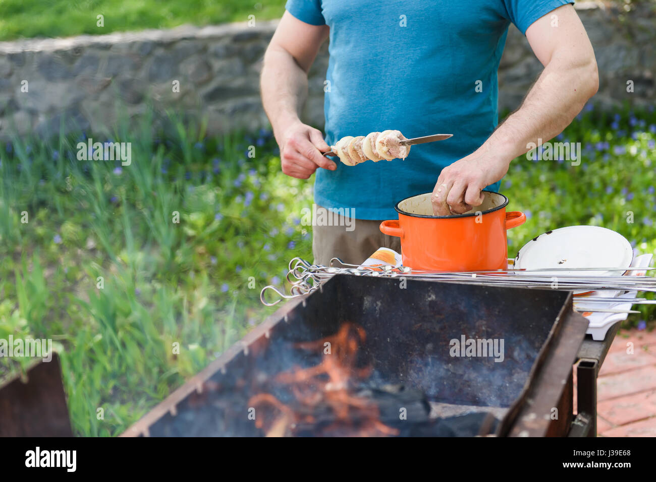 Man stringing meat on a skewer. Shashlik - cooking barbecue. Stringing ...