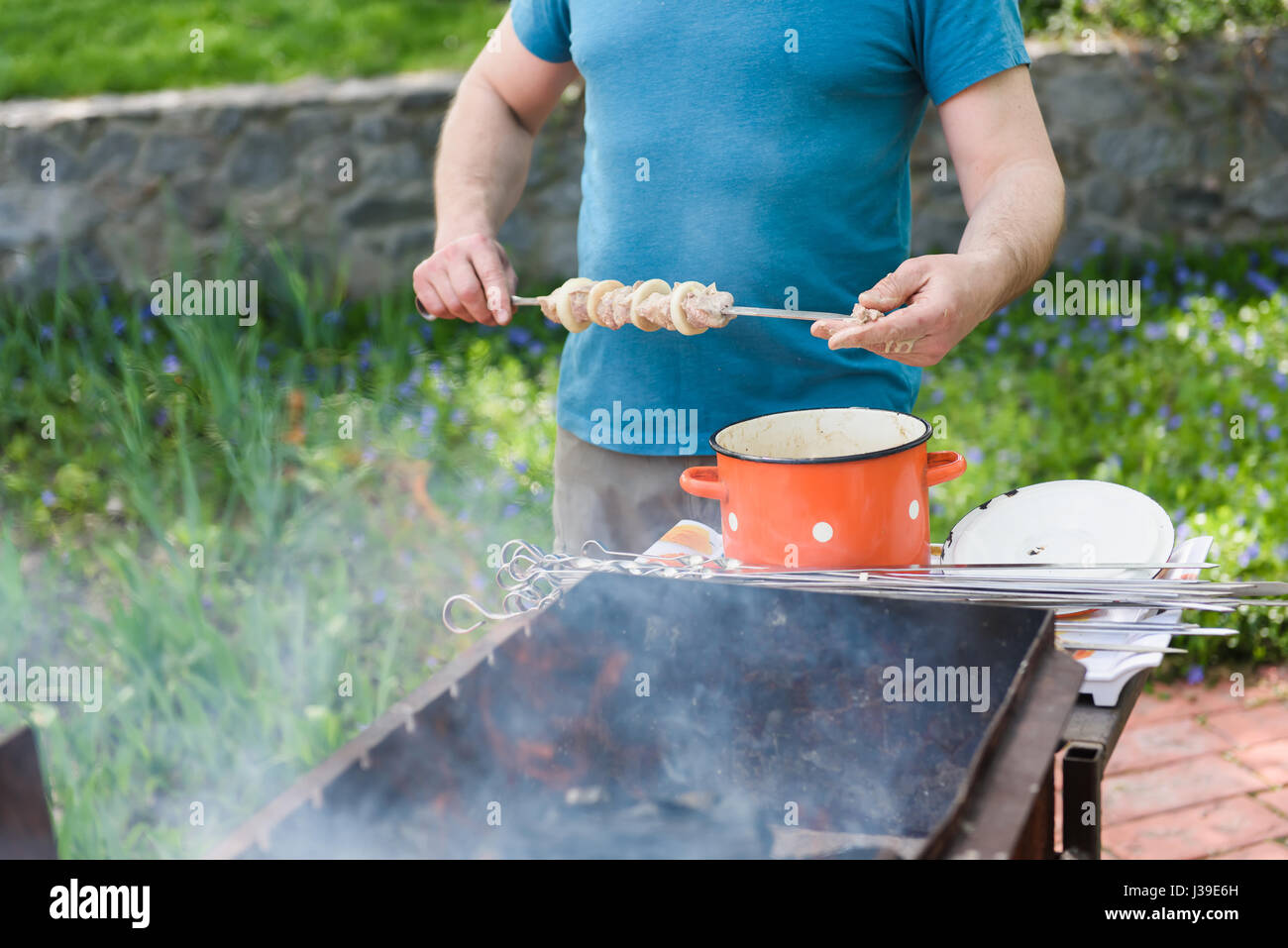 Man stringing meat on a skewer. Shashlik - cooking barbecue. Stringing ...