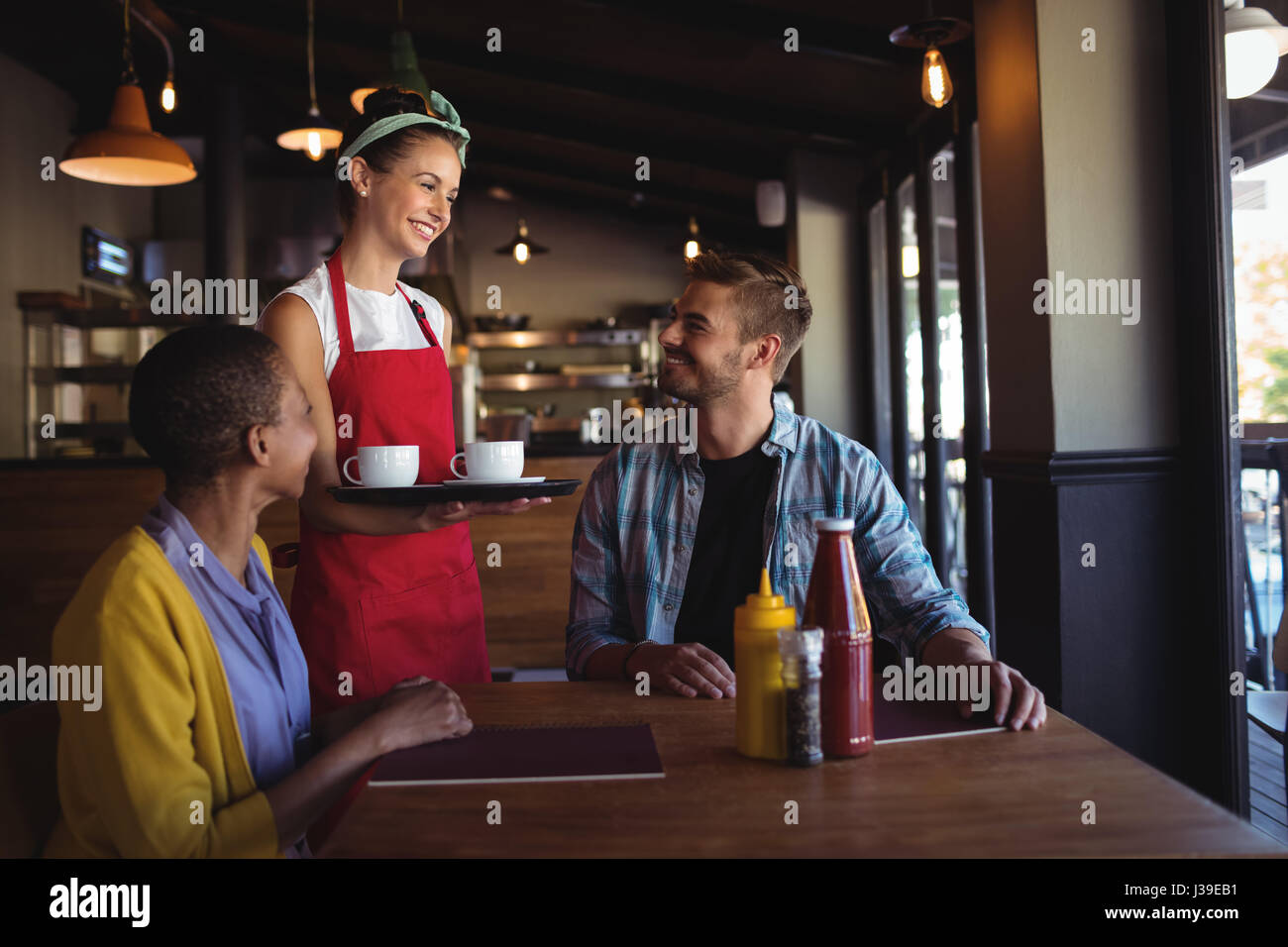 Waitress interacting with customer at restaurant Stock Photo - Alamy