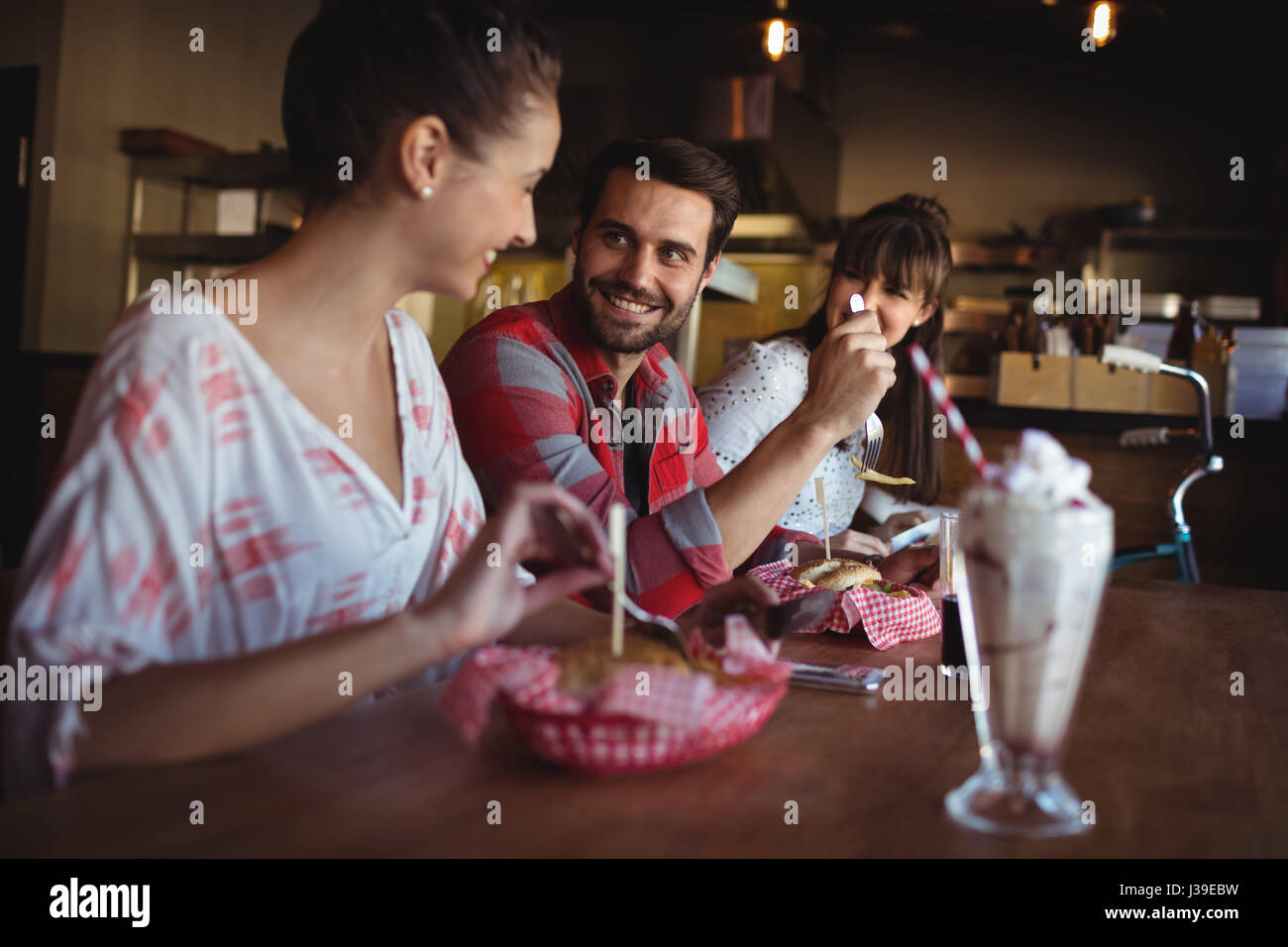 Friends having burger together Stock Photo - Alamy