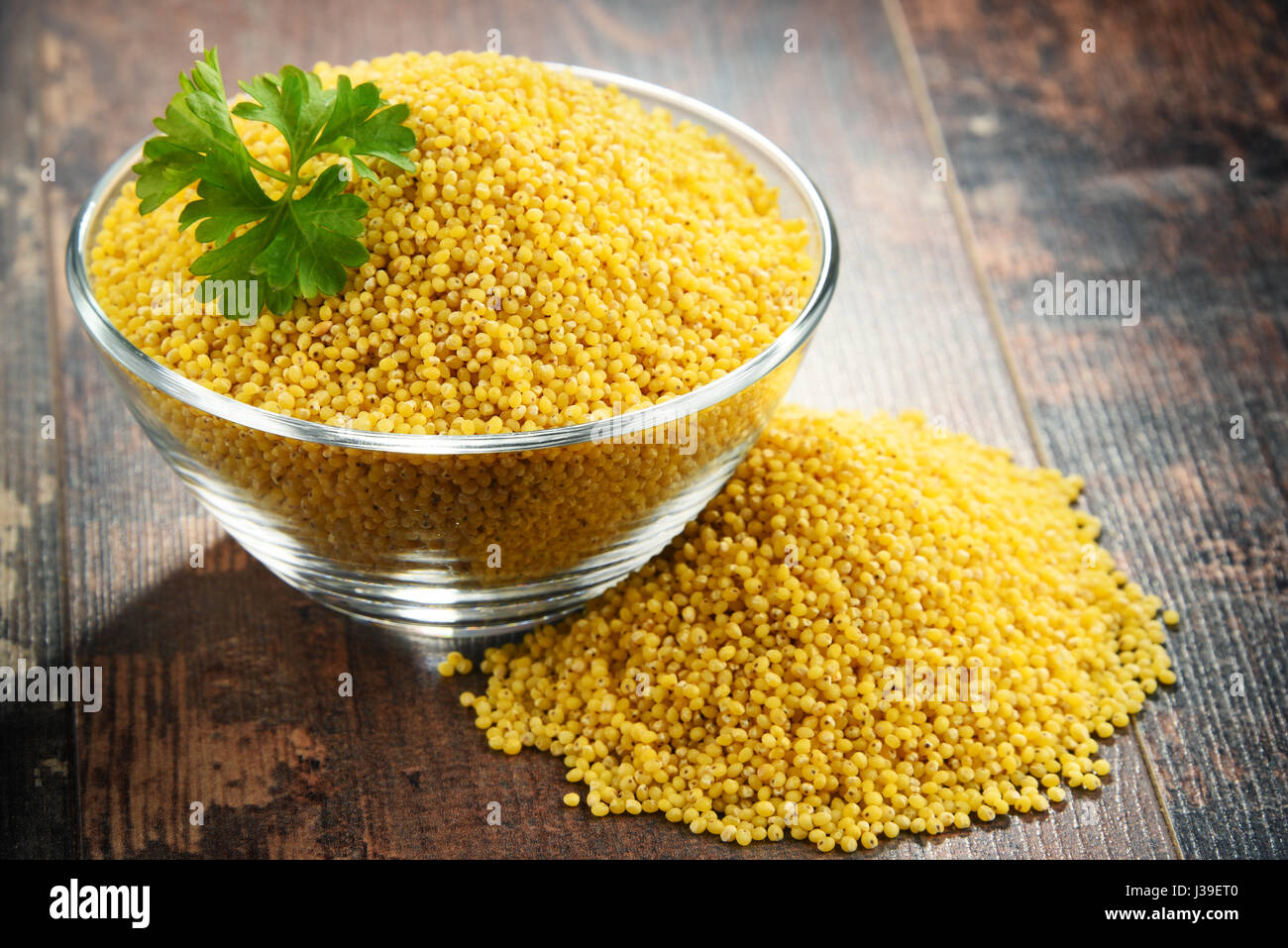 Composition with bowl of millet on wooden table Stock Photo - Alamy