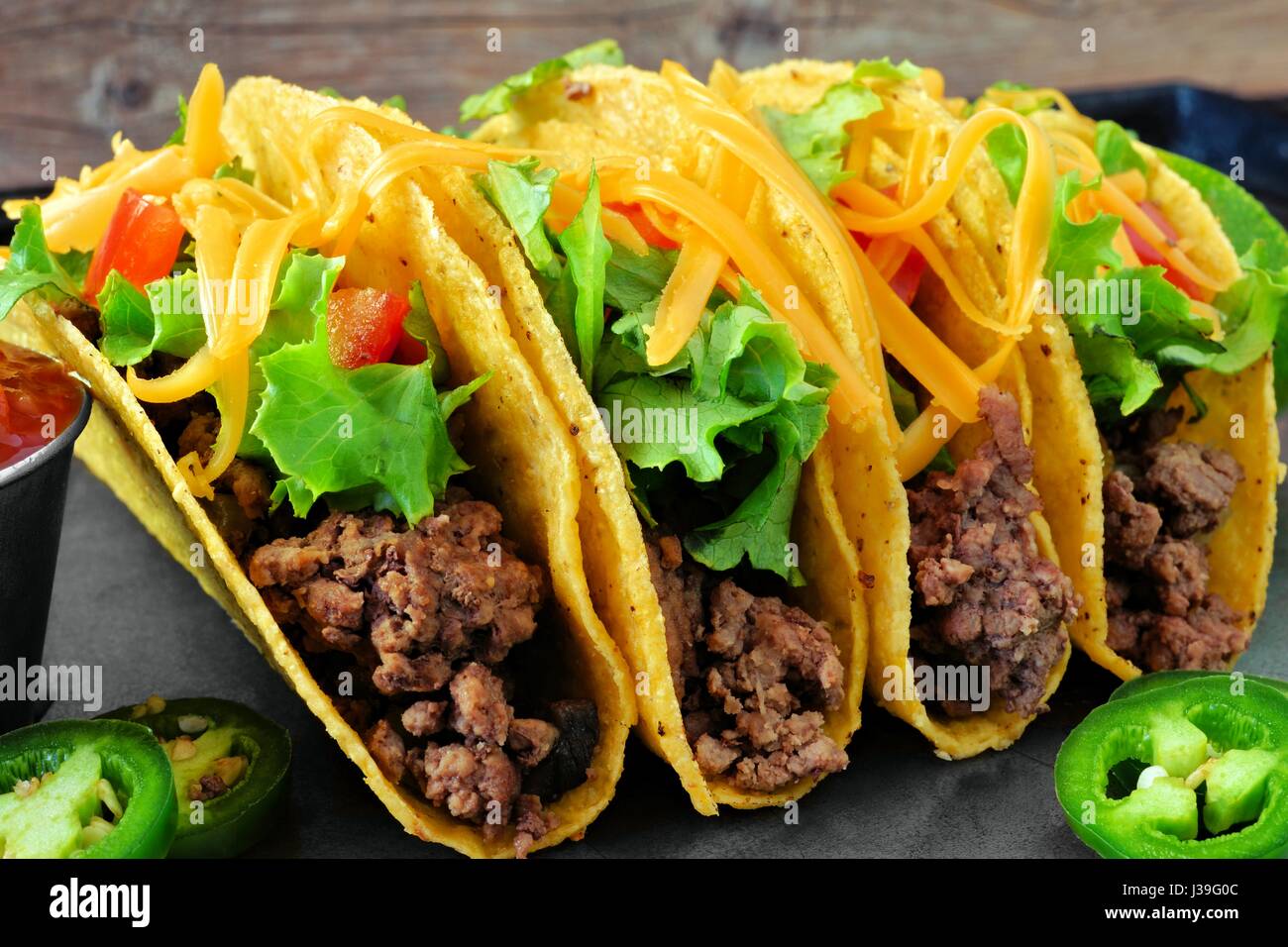 Group of hard shelled tacos with ground beef, lettuce, tomatoes and ...