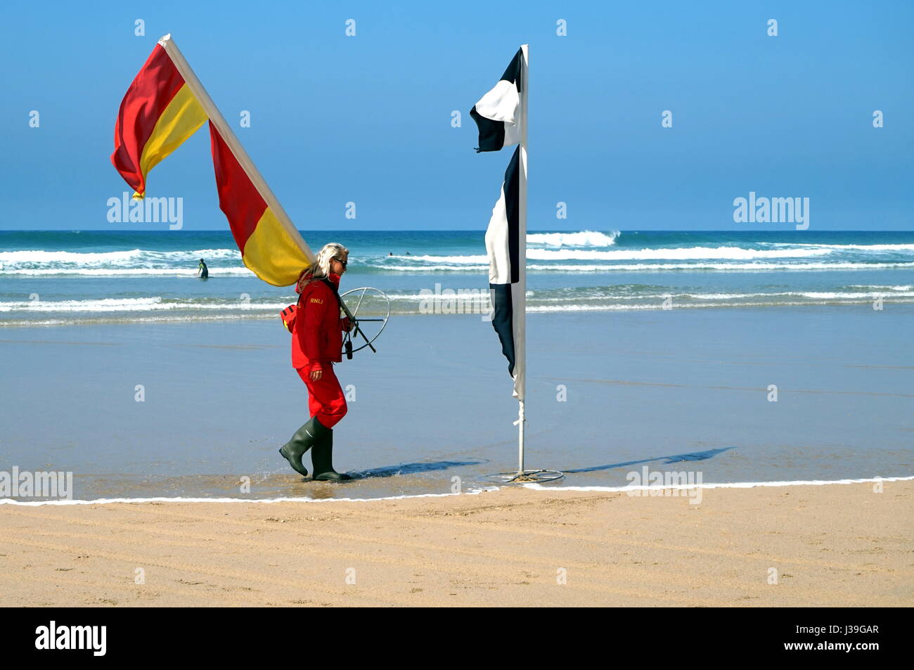 Newquay, Cornwall, UK - April 7 2017: Female RNLI lifeguard moving the ...
