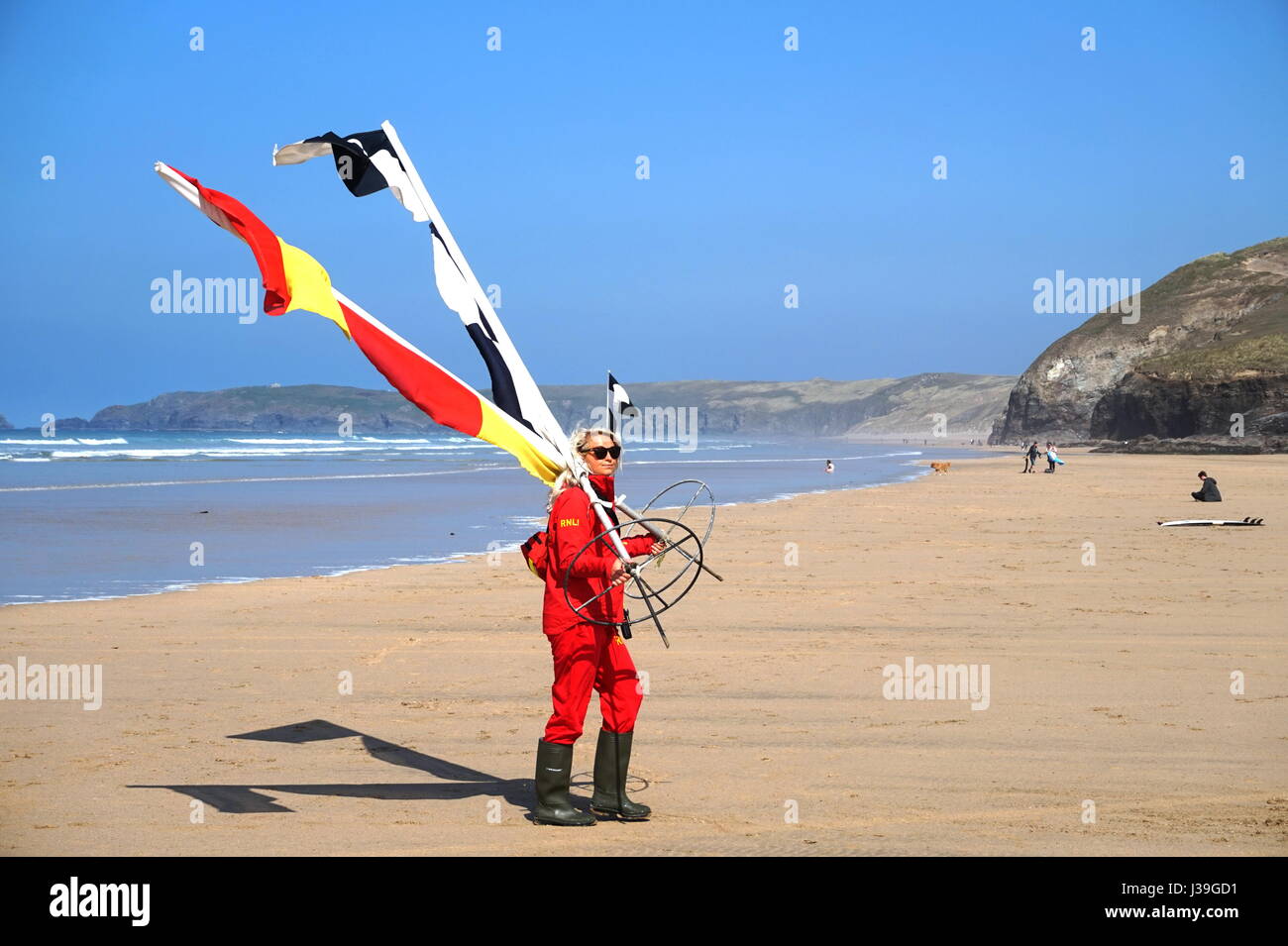 Newquay, Cornwall, UK - April 7 2017: Female RNLI lifeguard moving the ...