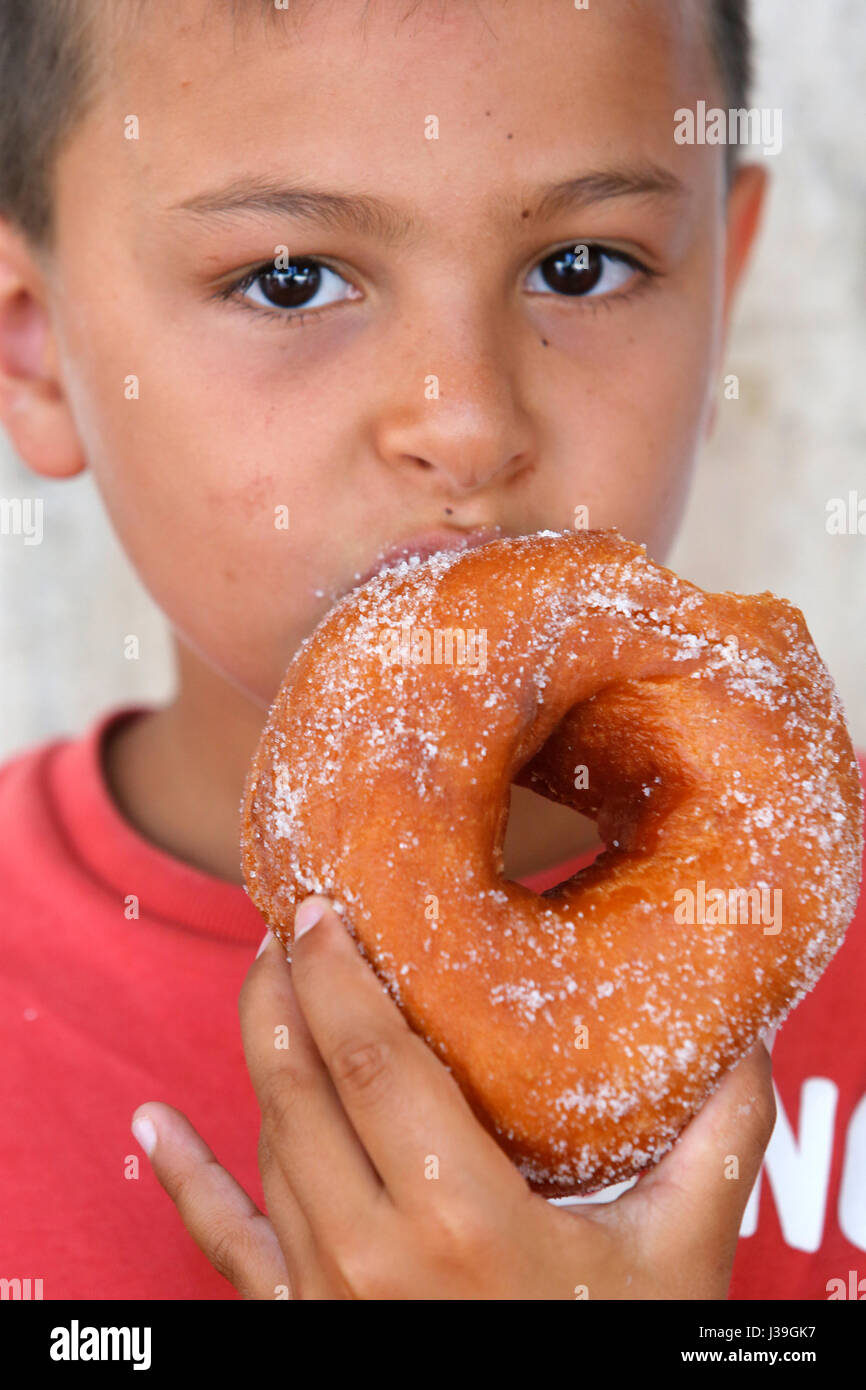 Boy eating a doughnut Stock Photo - Alamy