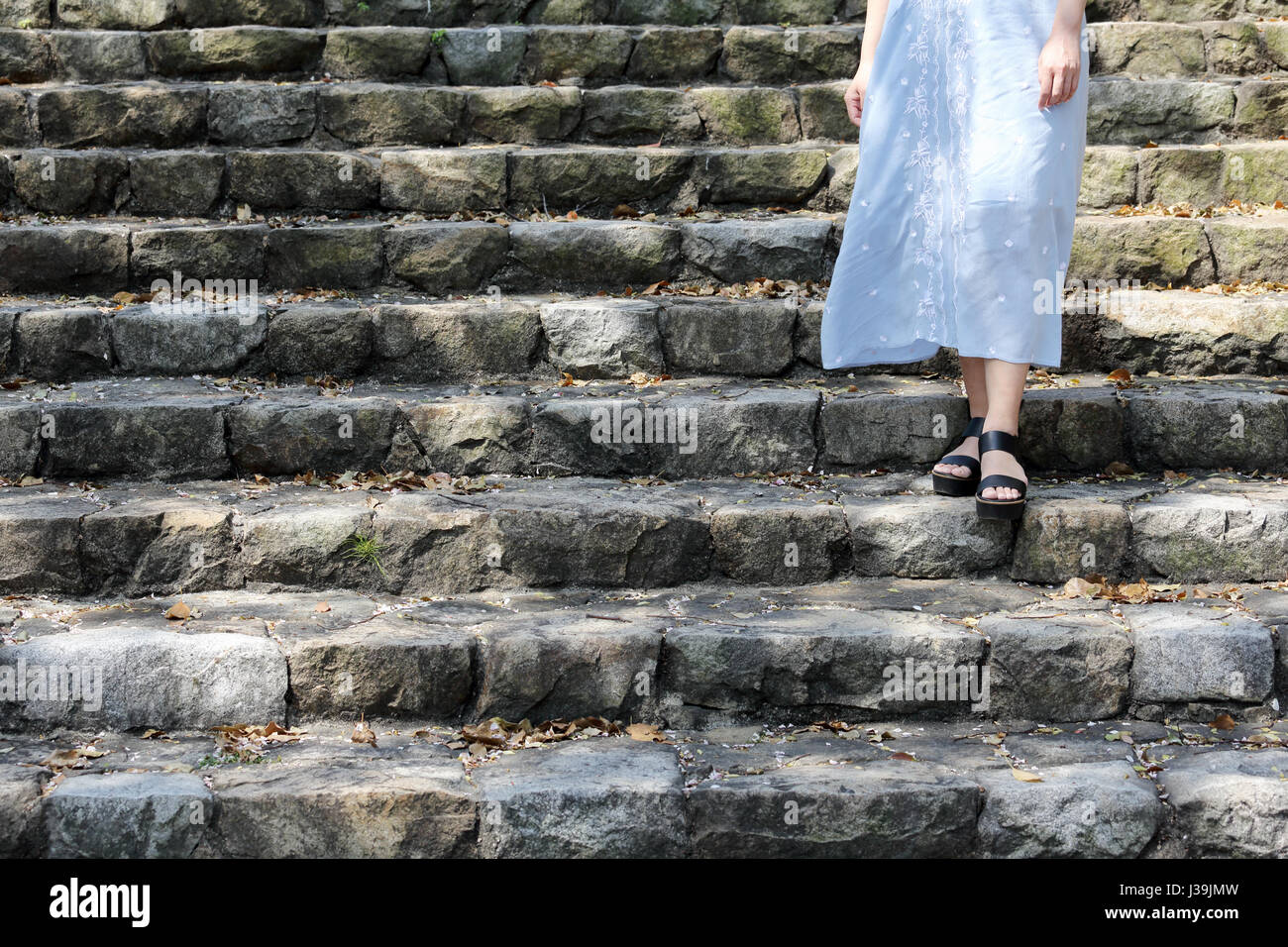 Young woman standing on the steps of a stone Stock Photo - Alamy