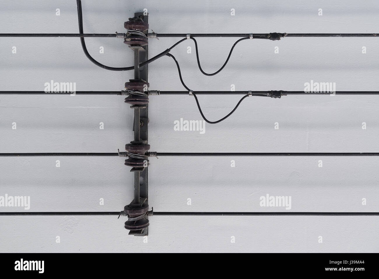 Power line and porcelain insulators with rack on white ceiling Stock ...