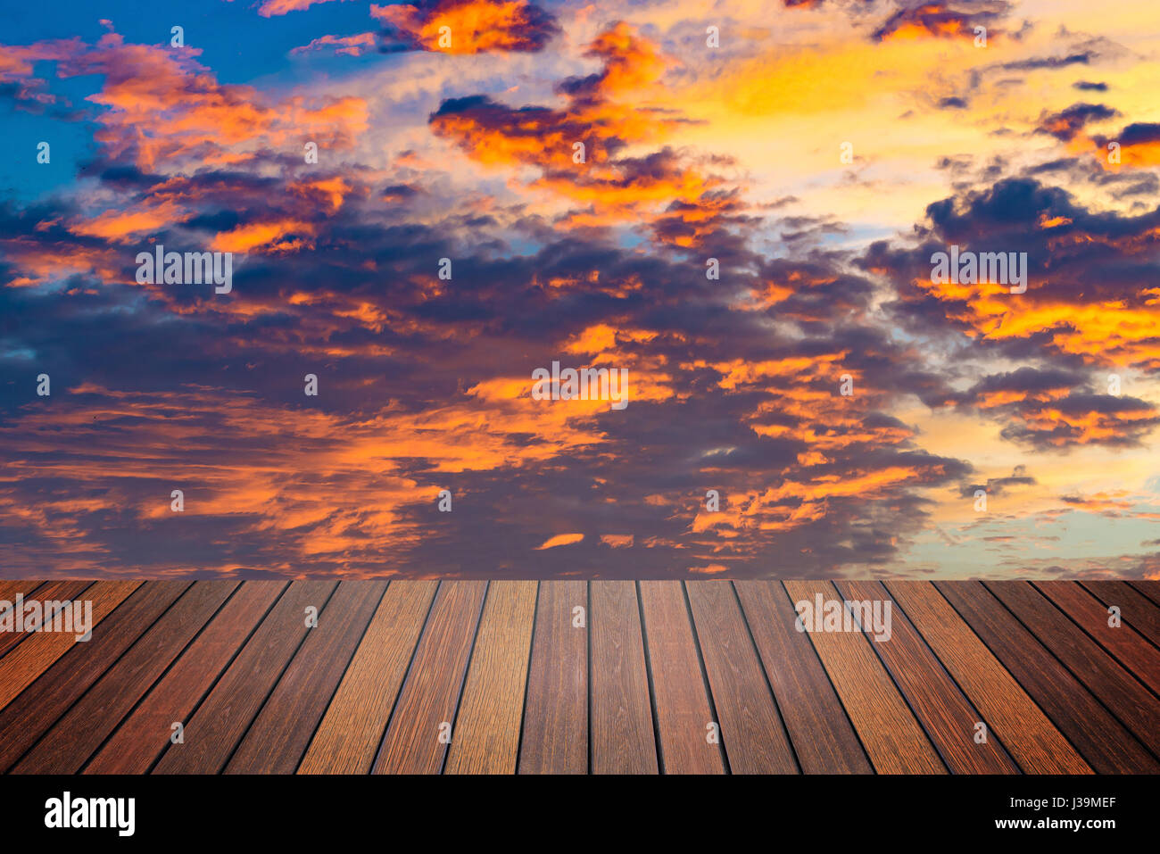 Wooden table or terrace on sunset sky and clouds, color and dark tone ...