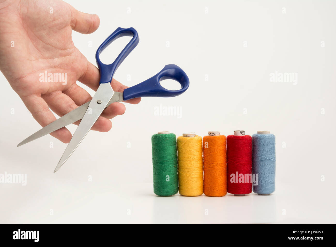 Multicolor Sewing Threads, Bobbins With A Hand Holding A Scissor ...