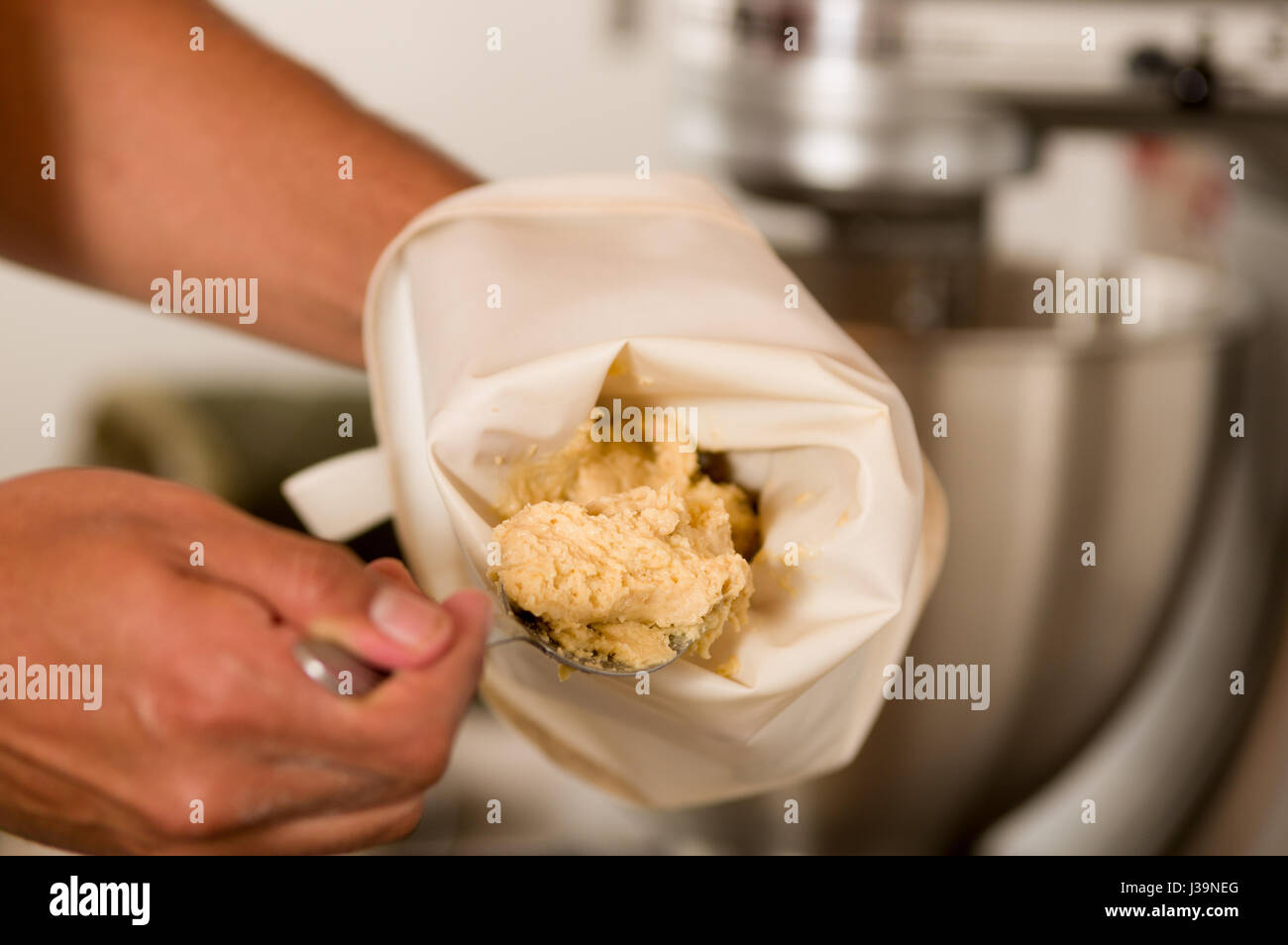 Bakery man add some buttercream inside of a piping bag Stock Photo - Alamy