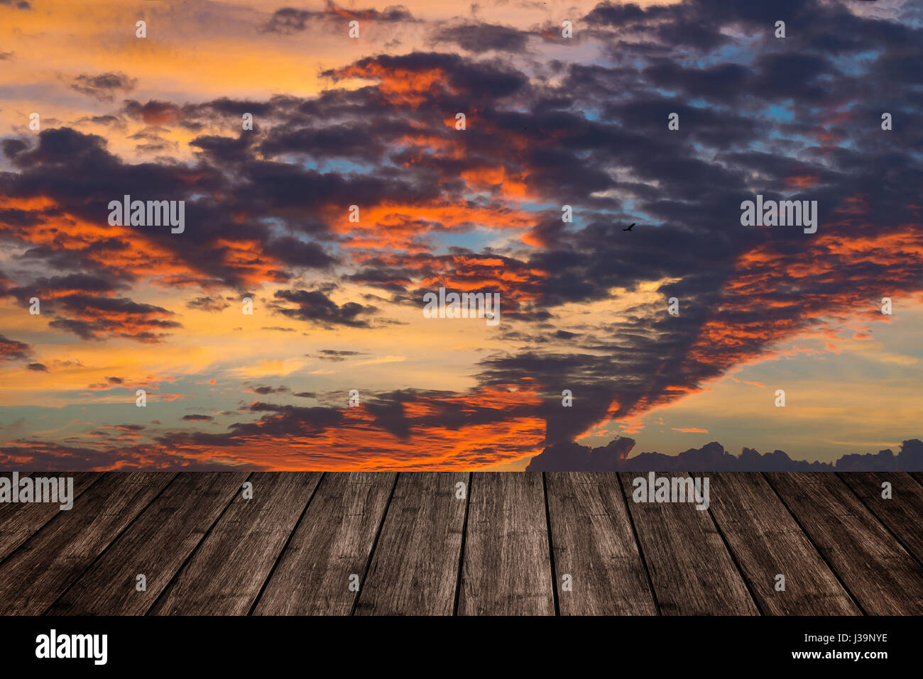 Wooden table or terrace on sunset sky and clouds, color and dark tone ...