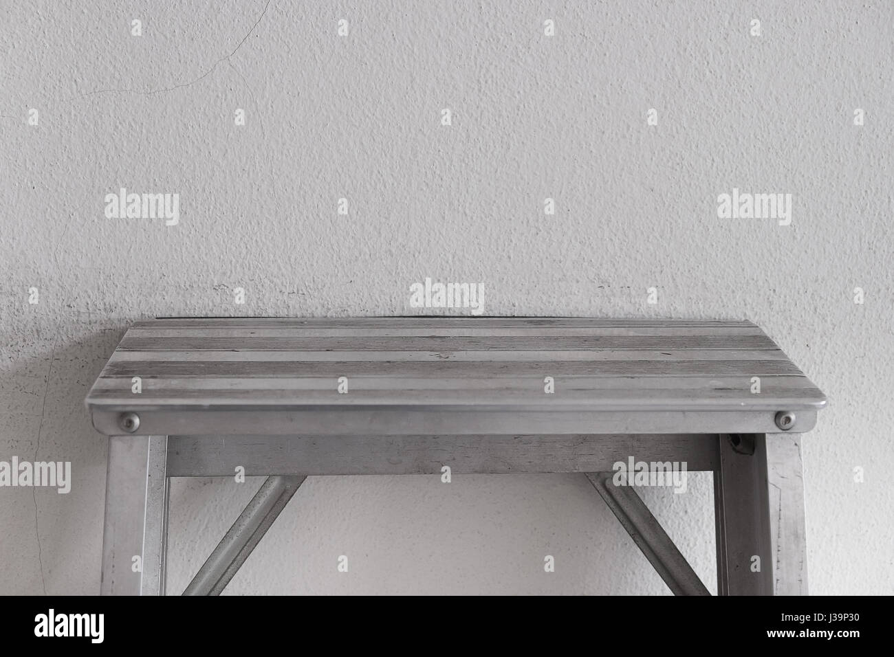 Aluminum ladder on the gray wall, room interior Stock Photo - Alamy