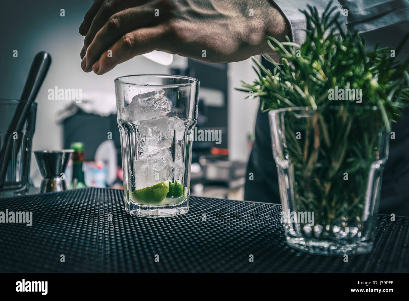 Glass filled with ice cubes. Bartender preparing cocktail Stock Photo ...