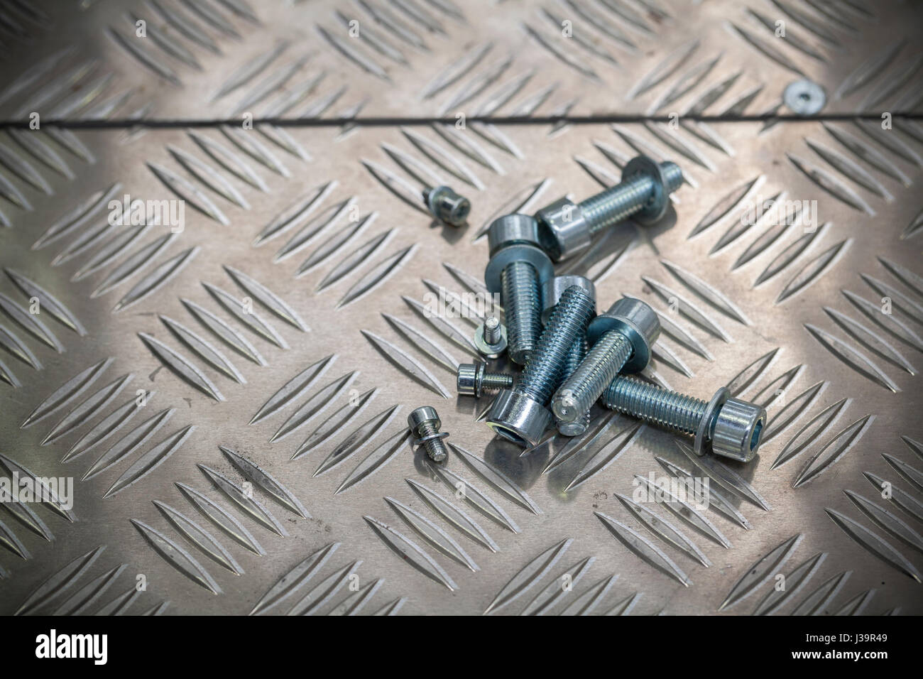steel screws on the metal plate, close up Stock Photo - Alamy