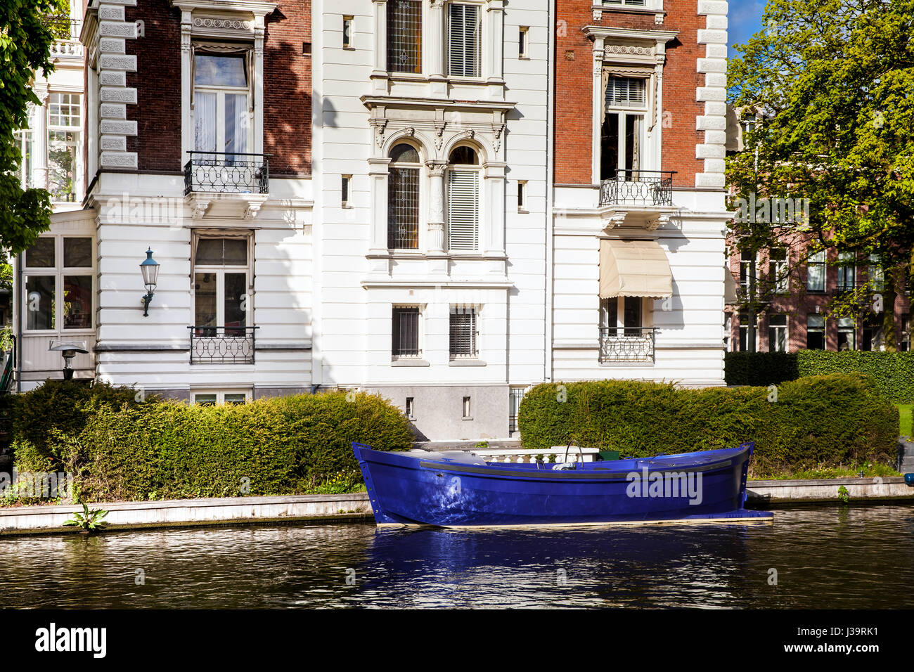 Blue boat on the canal of Amsterdam Stock Photo - Alamy