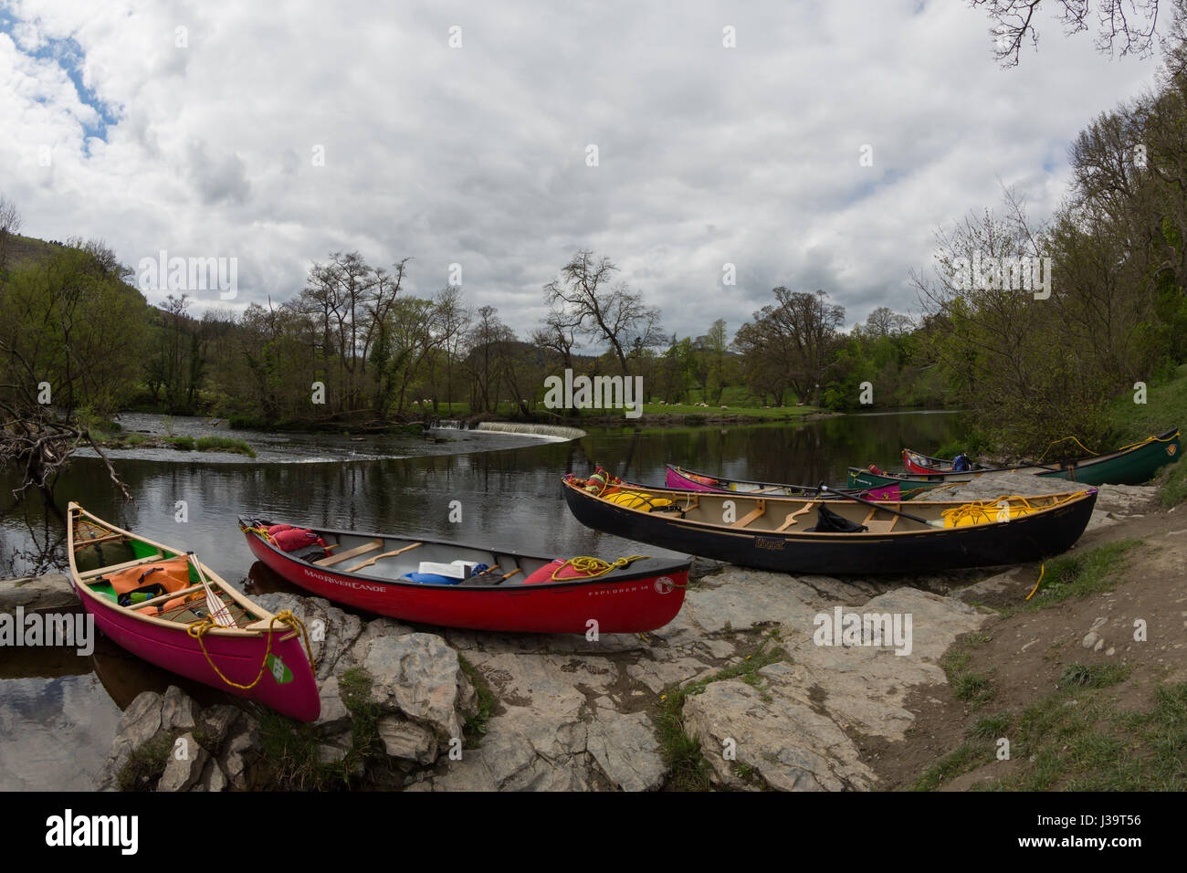 Canoes on the bank of the River Dee near Llangollen. In the background ...