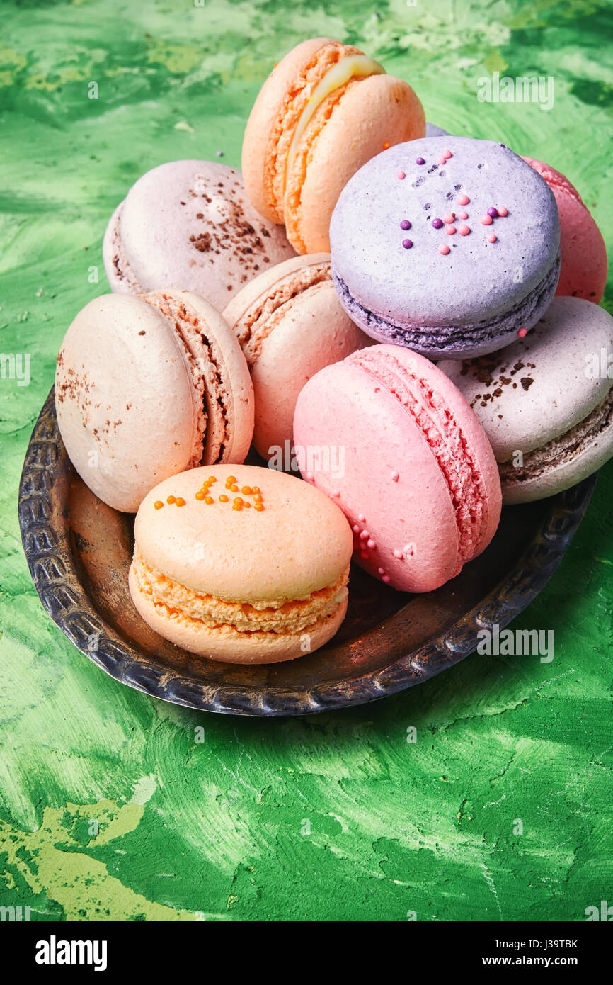 French macaroons dessert on a green background Stock Photo - Alamy