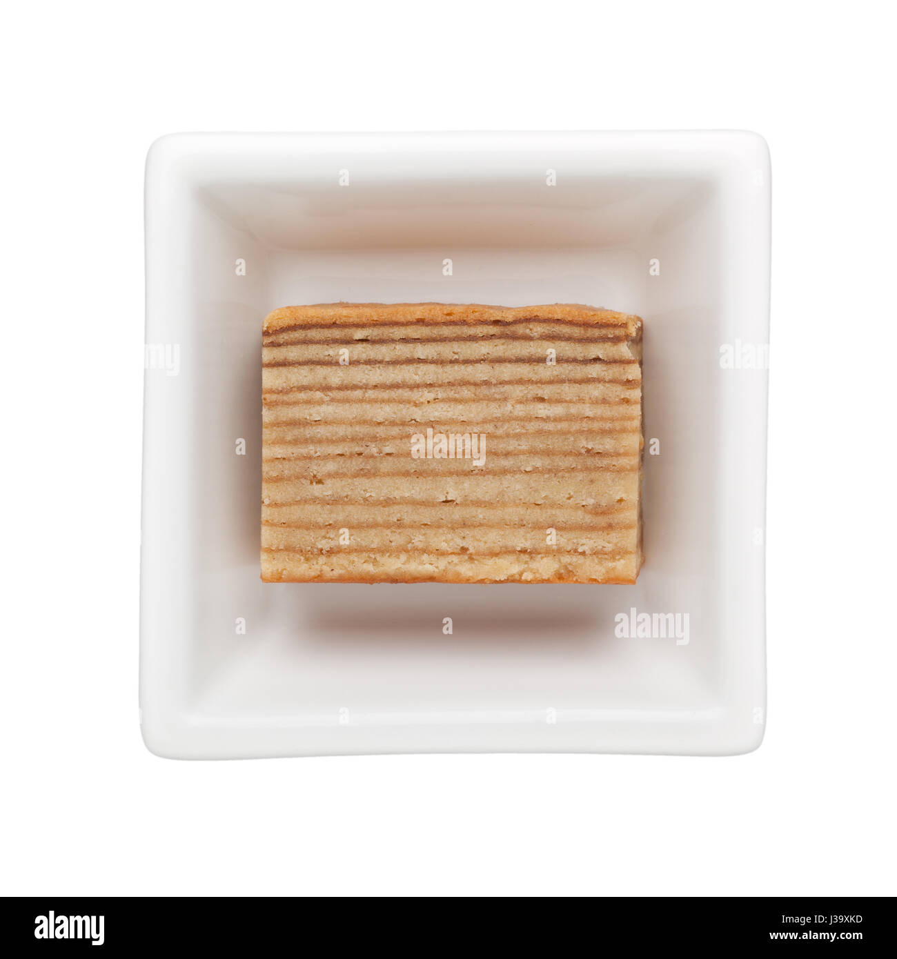Slice of Kek lapis in a square bowl isolated on white background Stock ...