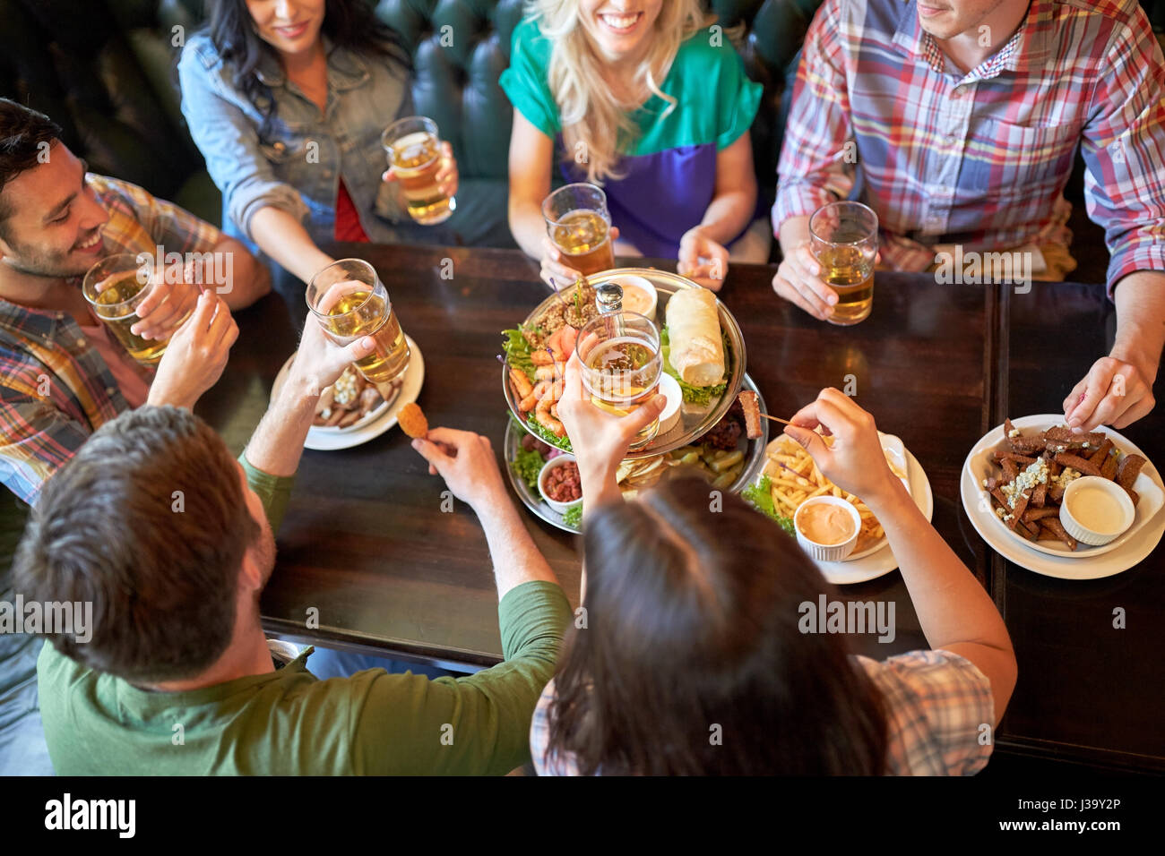 happy friends eating and drinking at bar or pub Stock Photo - Alamy