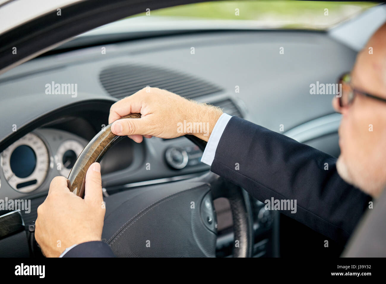 senior businessman hands driving car Stock Photo - Alamy
