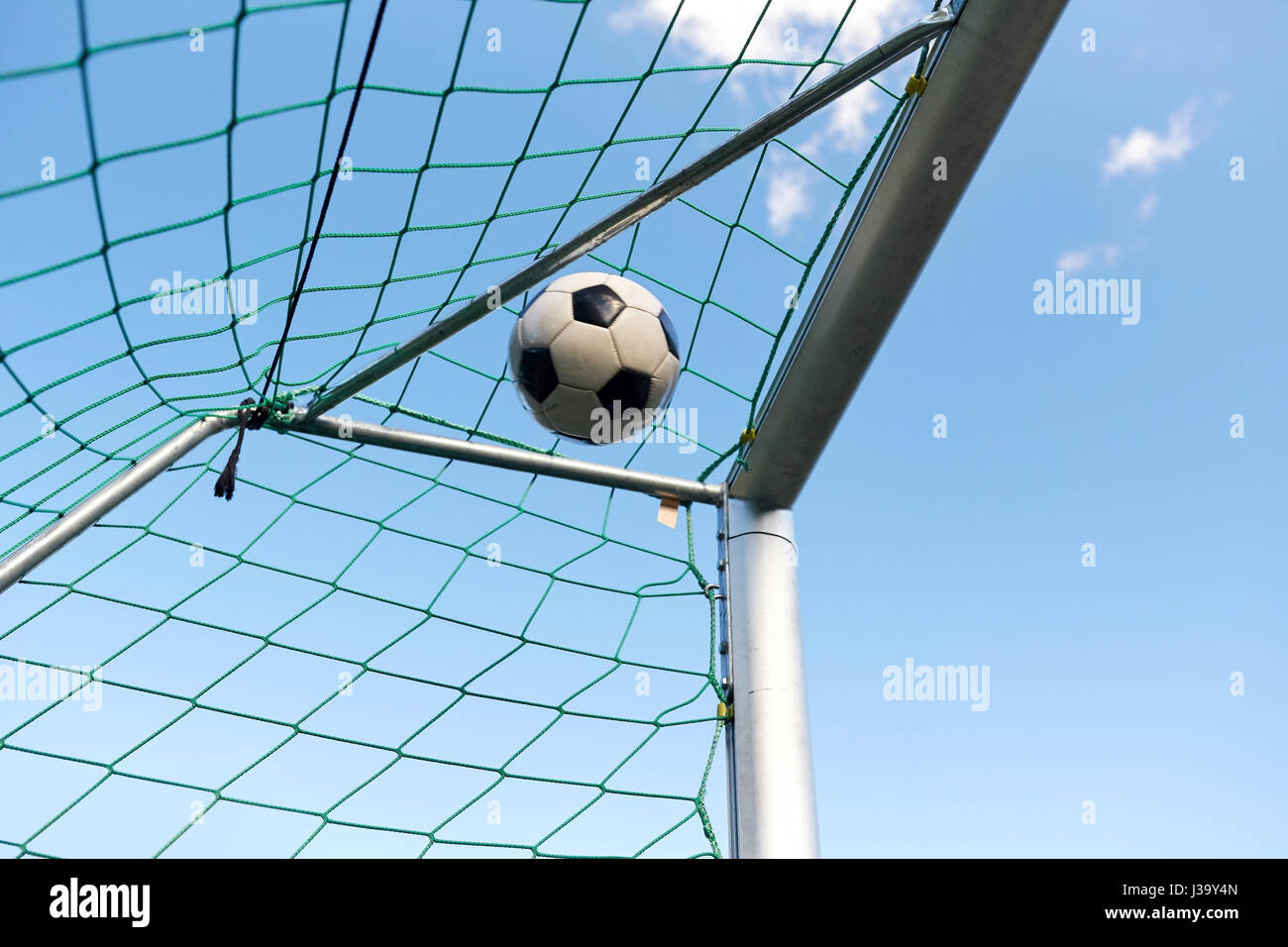 soccer ball flying into football goal net over sky Stock Photo - Alamy