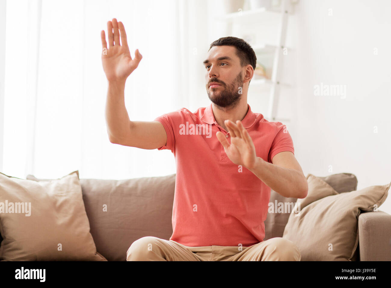 man touching something imaginary at home Stock Photo - Alamy