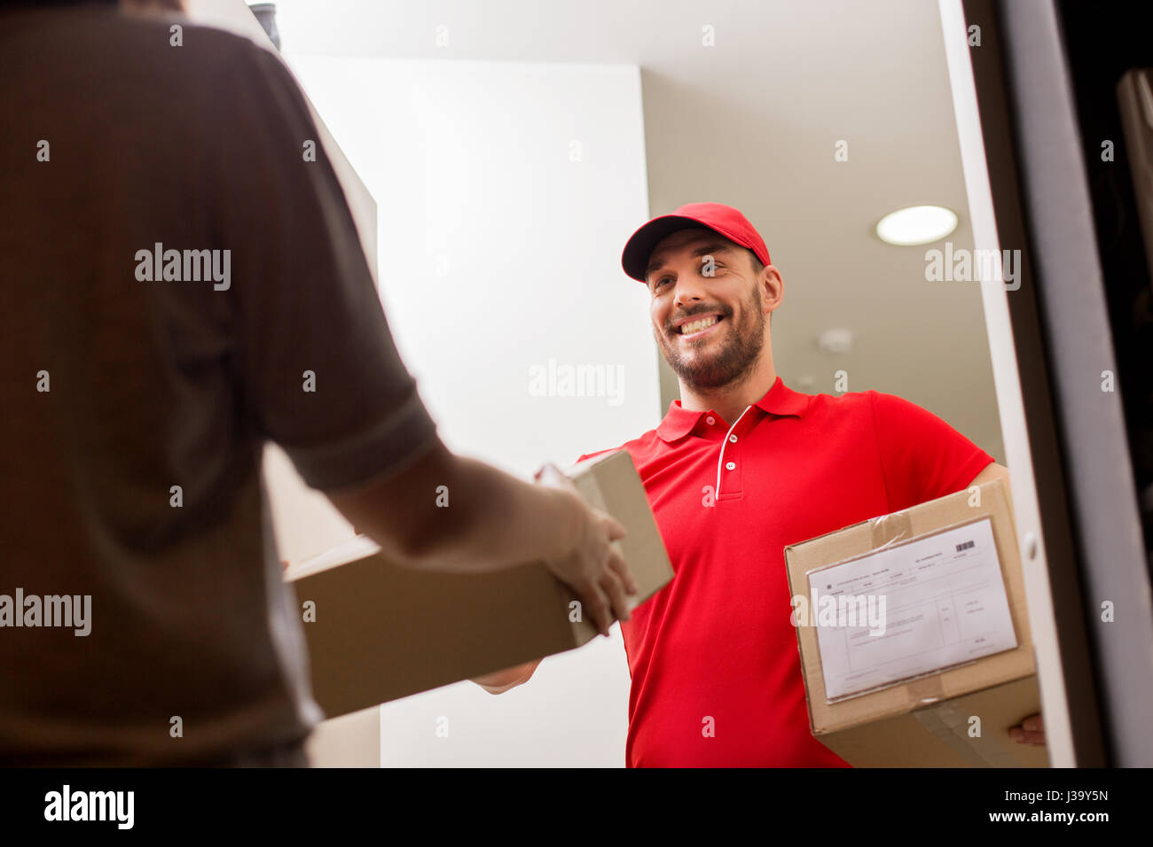 happy delivery man giving parcel box to customer Stock Photo - Alamy