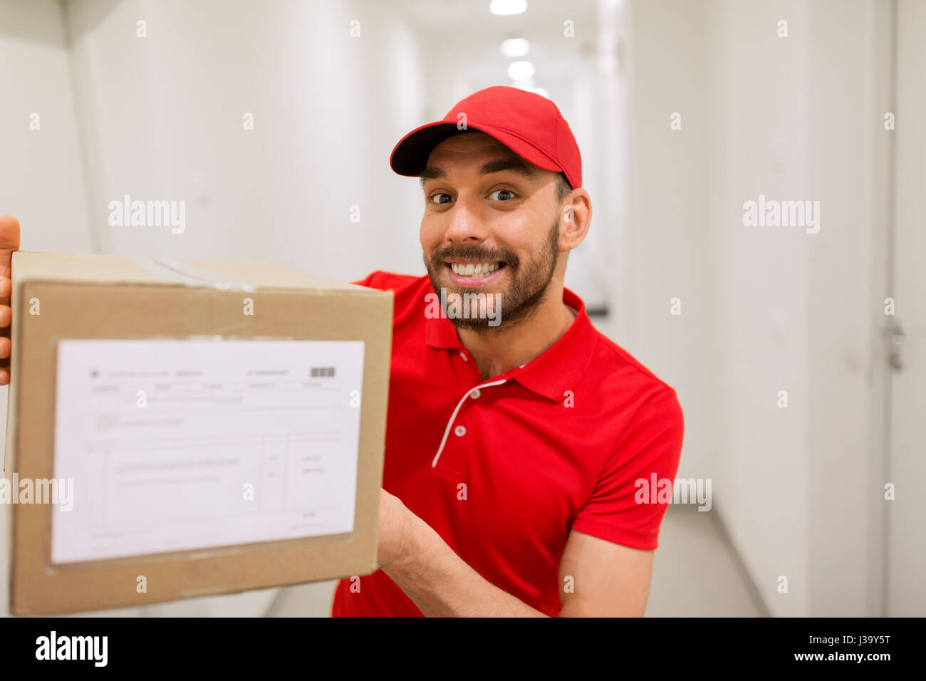 delivery man with parcel box in corridor Stock Photo - Alamy