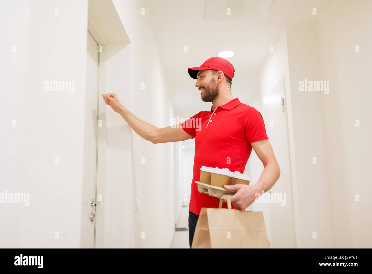 delivery man with coffee and food knocking on door Stock Photo - Alamy