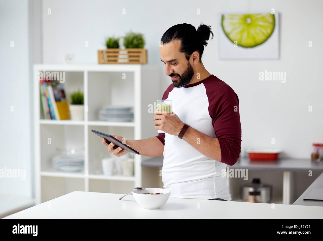 man with tablet pc eating breakfast at home Stock Photo - Alamy