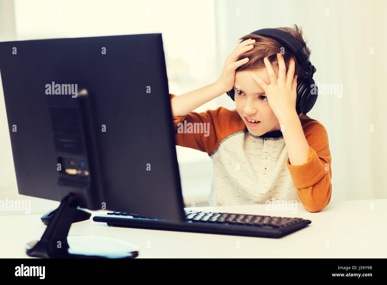 terrified boy with computer and headphones at home Stock Photo - Alamy