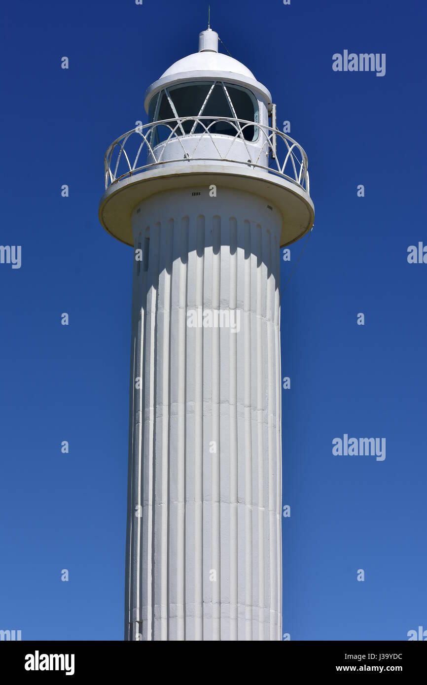 Top part of white lighthouse showing circular railing and glass panes ...