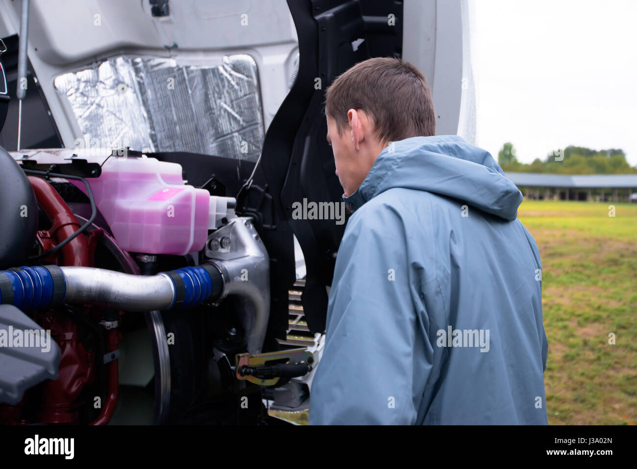 Truck driver checks the engine of huge modern powerful big rig semi ...