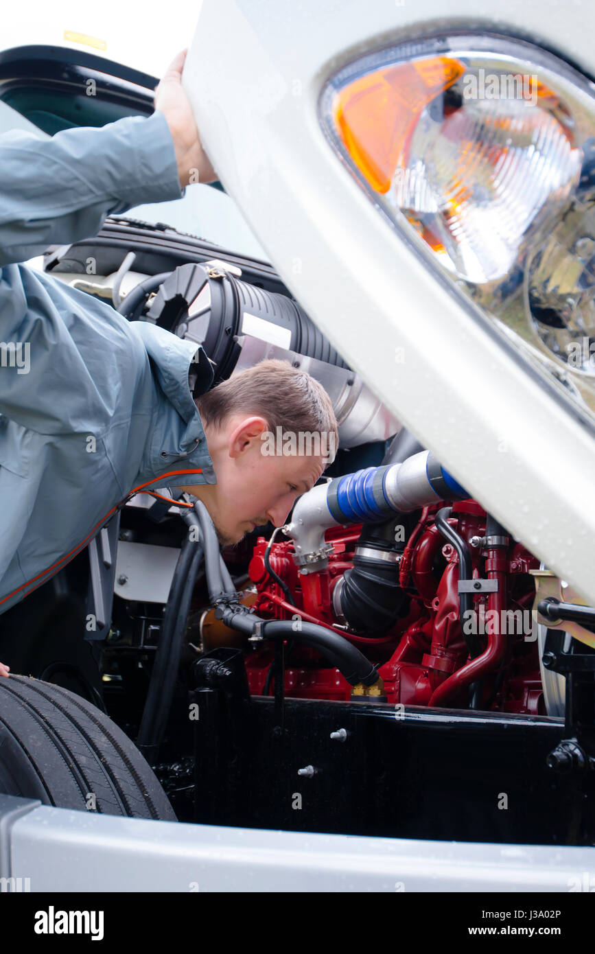 The professional Truck driver inspect his heavy semi truck engine to ...