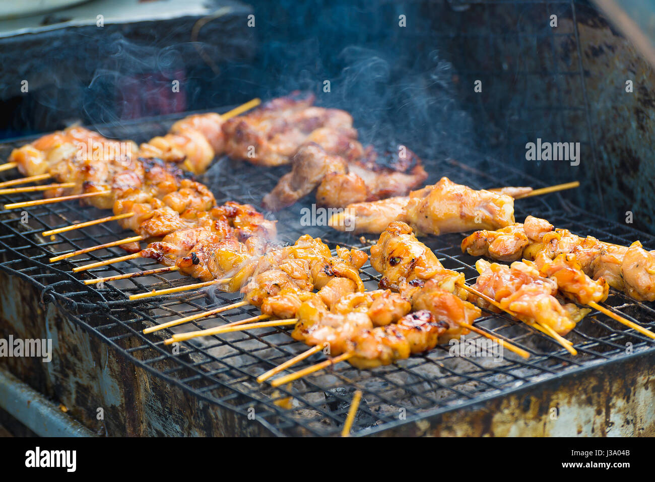 Chicken grill over the small flame with smoke Stock Photo - Alamy