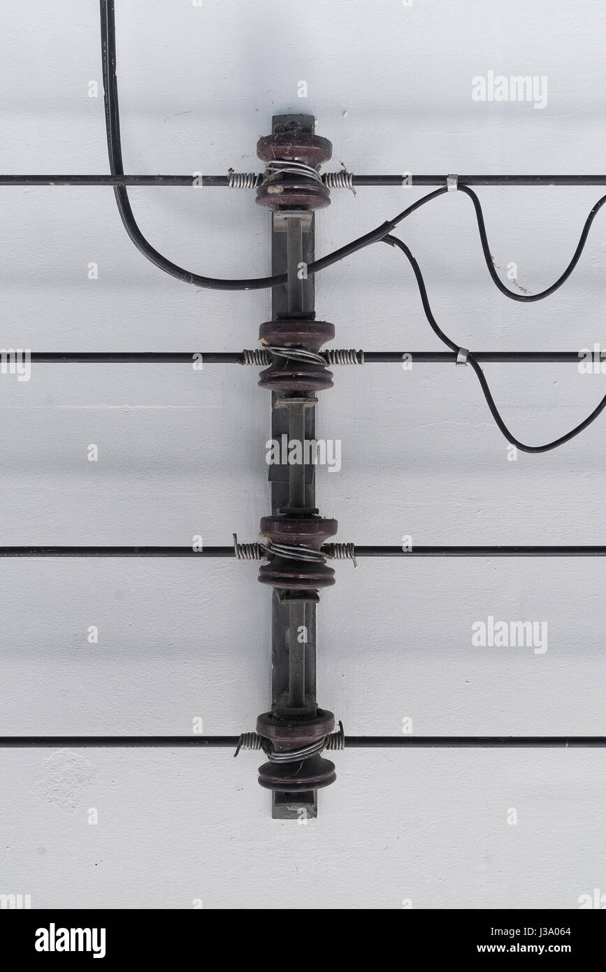 Power line and porcelain insulators with rack on white ceiling Stock ...