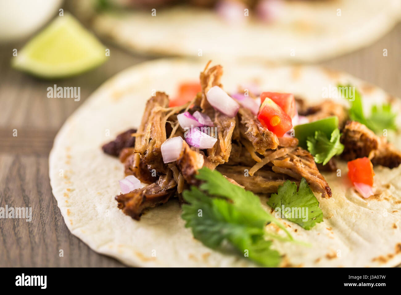 Pulled pork carnitas with pico de gallo on a flour tortilla Stock Photo ...