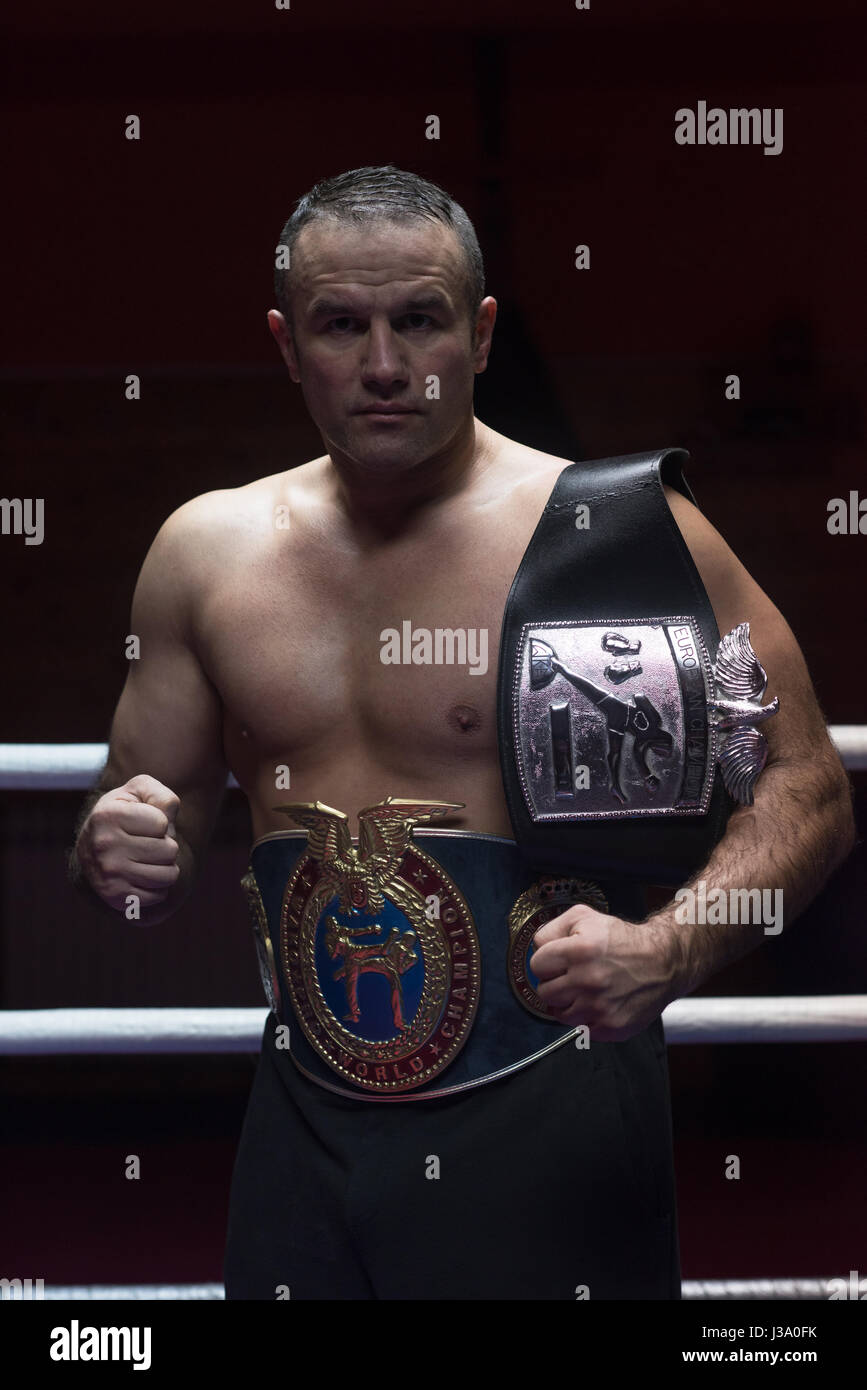 portrait of muscular professional kick boxer with his championship belt ...
